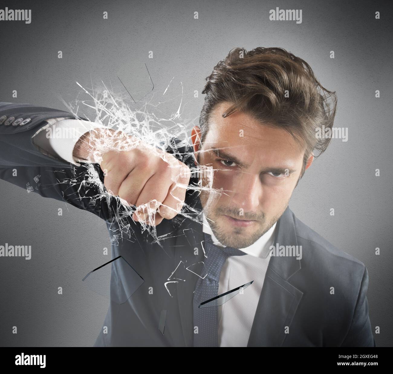 Determined businessman breaks the glass with punch Stock Photo - Alamy