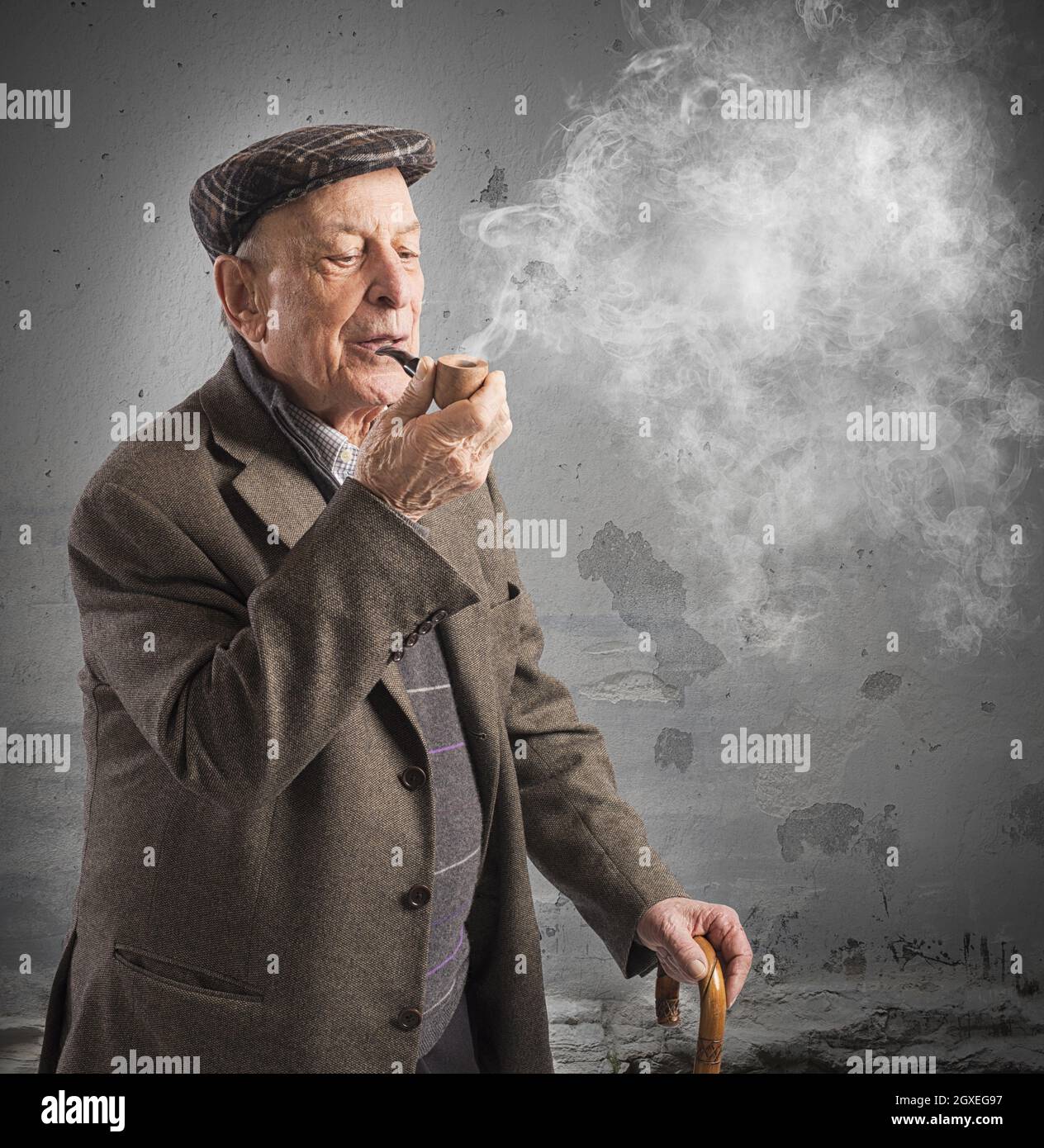 Old man reflecting while smoking his pipe Stock Photo - Alamy