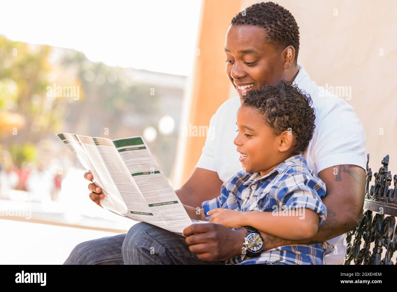 Happy African American Father and Mixed Race Son Having Fun Reading ...
