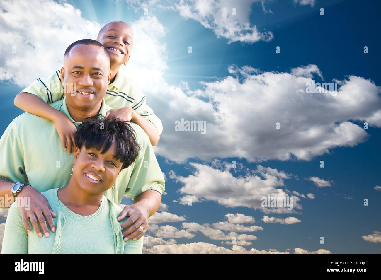 Happy African American Family Over Blue Sky, Sun Rays and Clouds Stock ...
