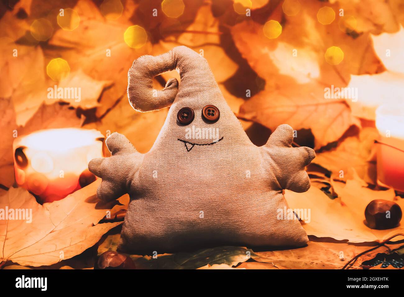 Toy monster with button eyes among autumn leaves. Halloween holiday ...
