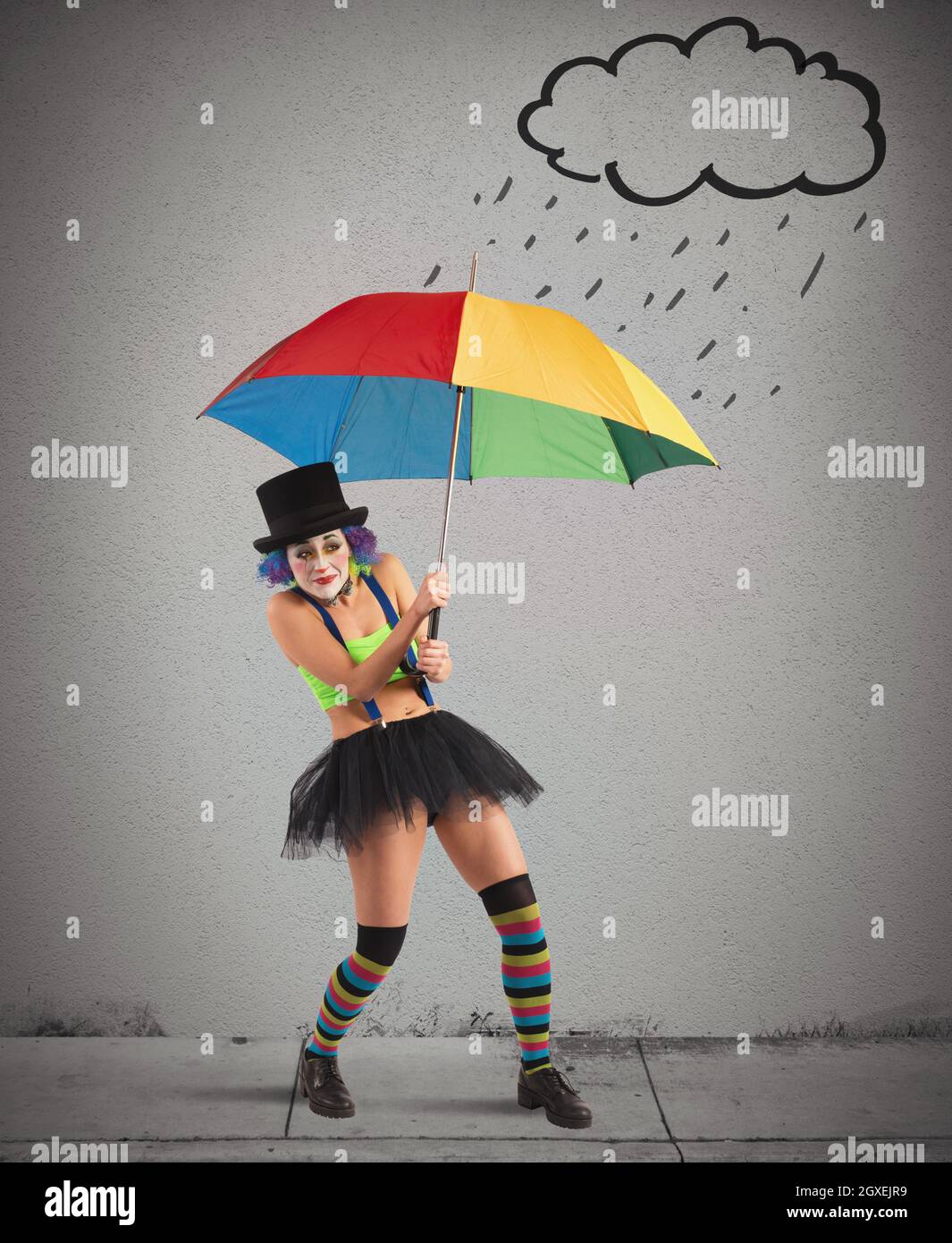 Clowns with rainbow umbrella sheltering from rain Stock Photo - Alamy