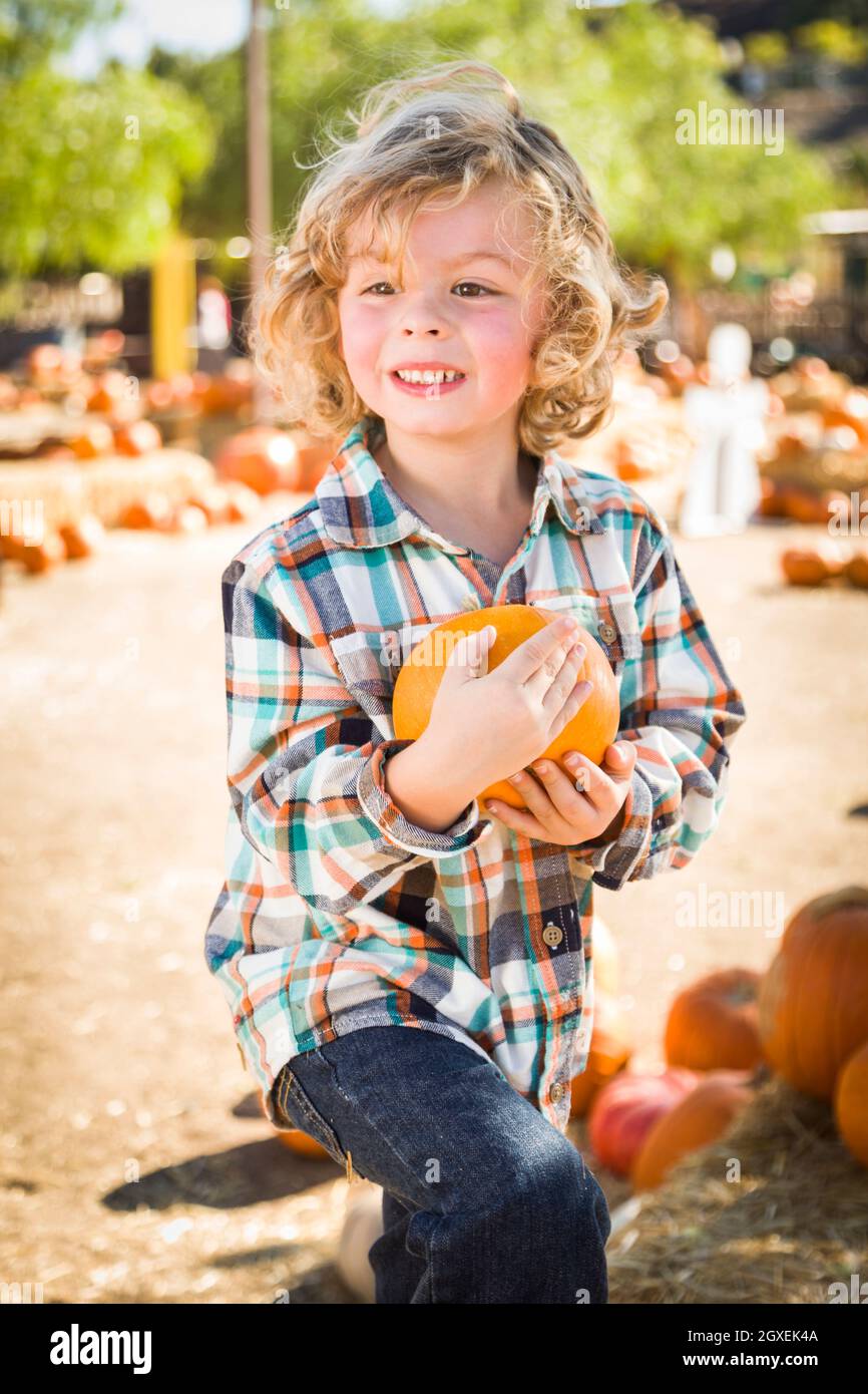 Adorable Little Boy Sitting and Holding His Pumpkin in a Rustic Ranch ...
