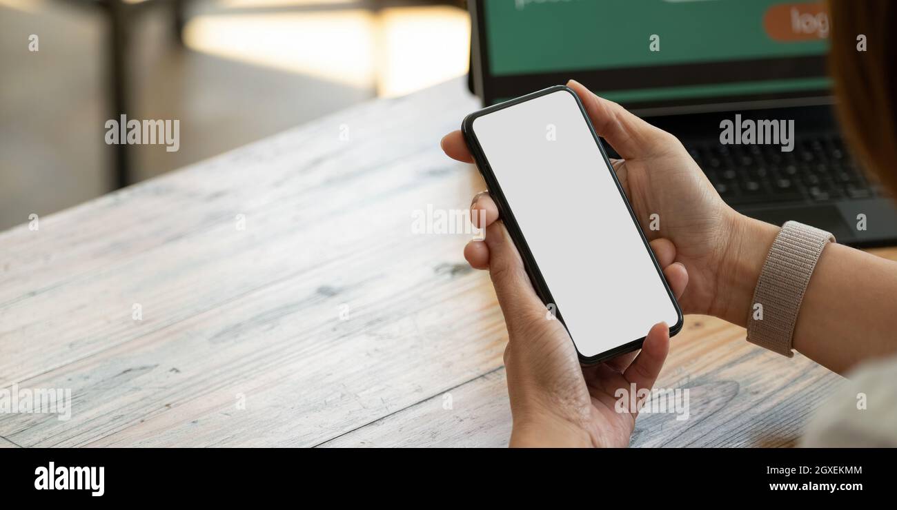 Close up hands using blank screen mobile smart phone with notebook and ...