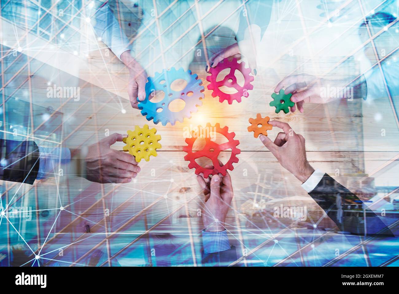 Teamwork of businesspeople work together and combine pieces of gears ...
