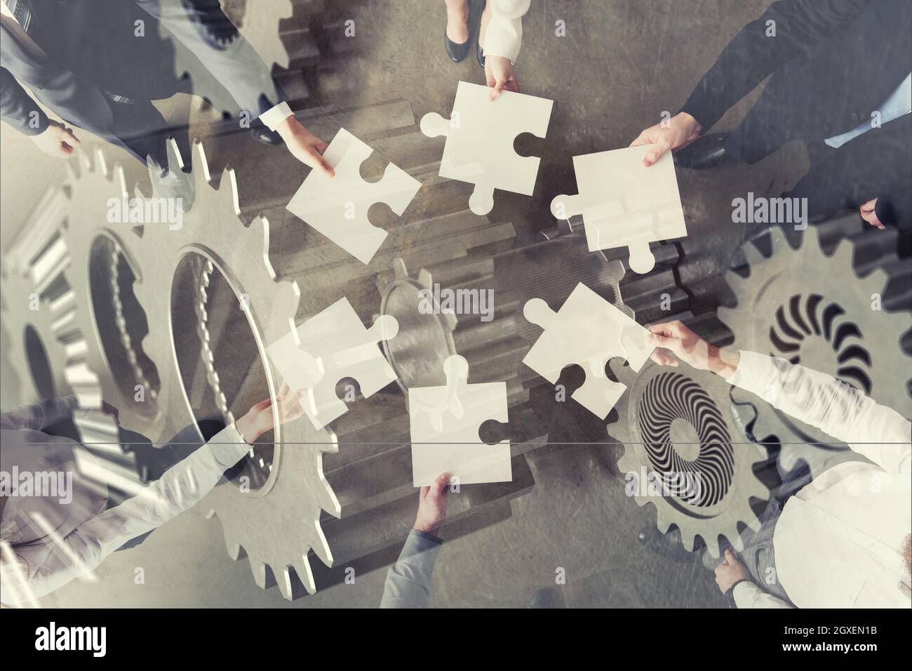 Businessmen working together to build a colored puzzle with gear overlay. Concept of teamwork ...