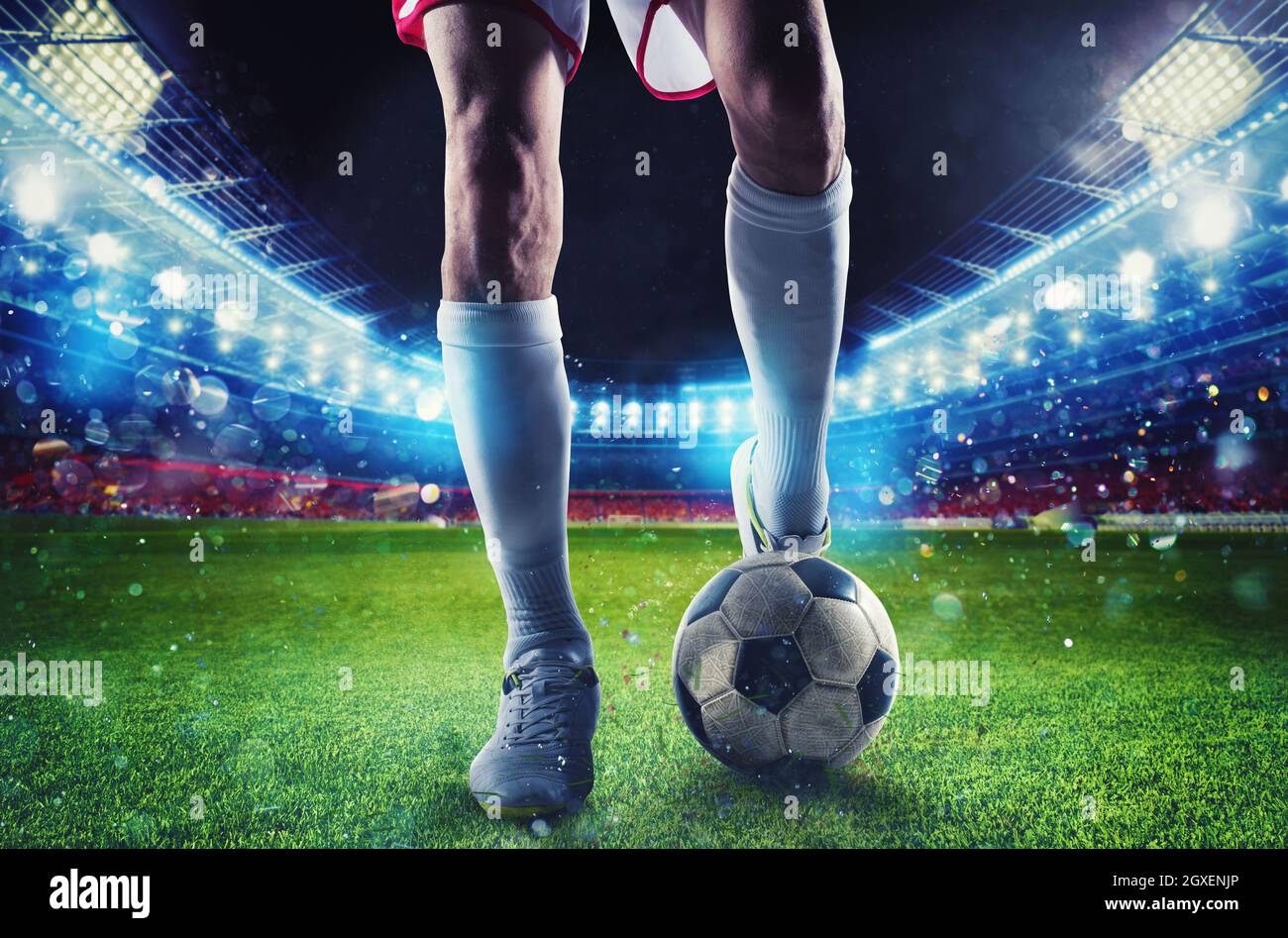 Soccer player ready to kick the soccerball at the illuminated stadium ...