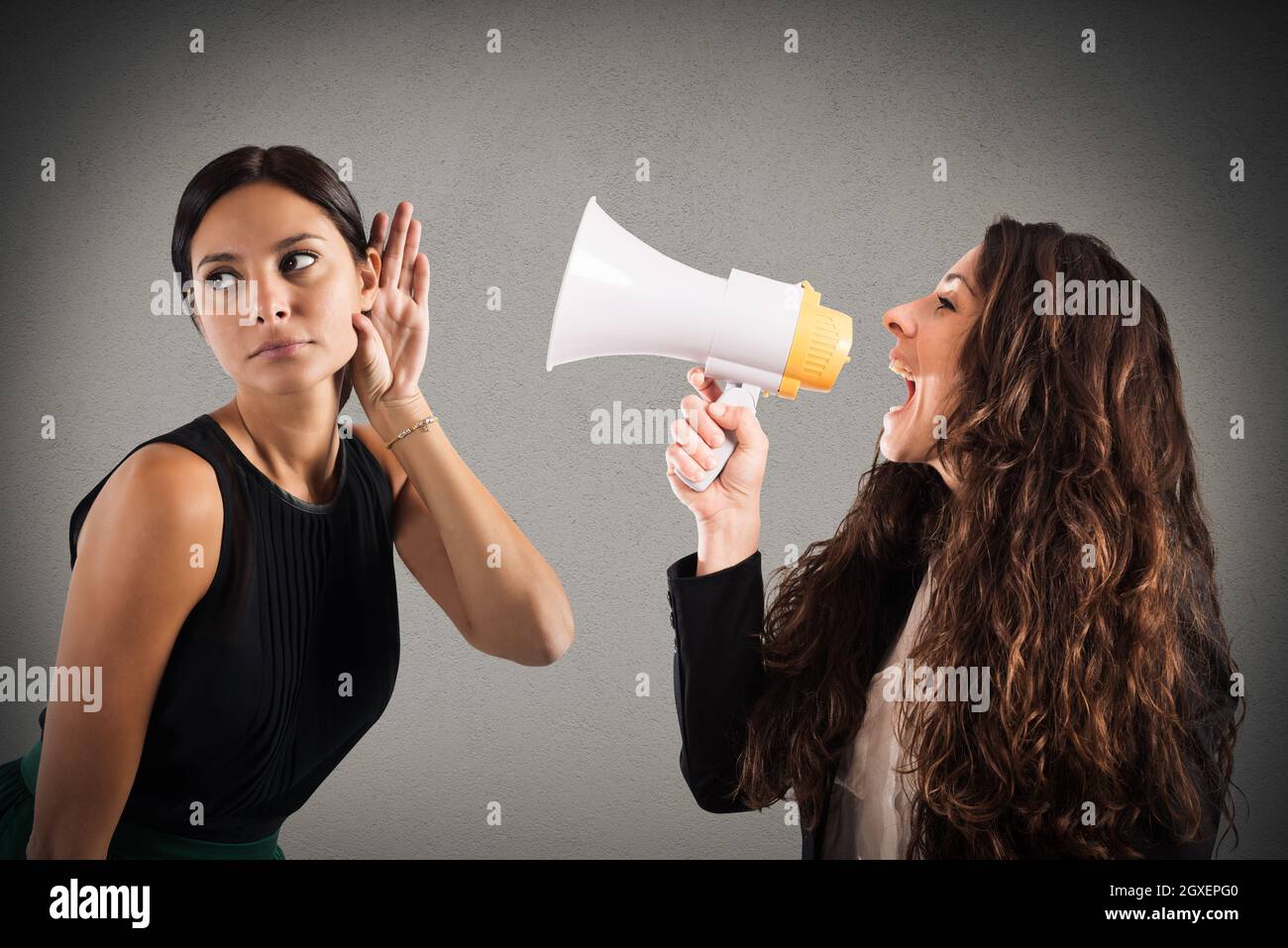 Woman with megaphone shouting to another woman listening Stock Photo ...