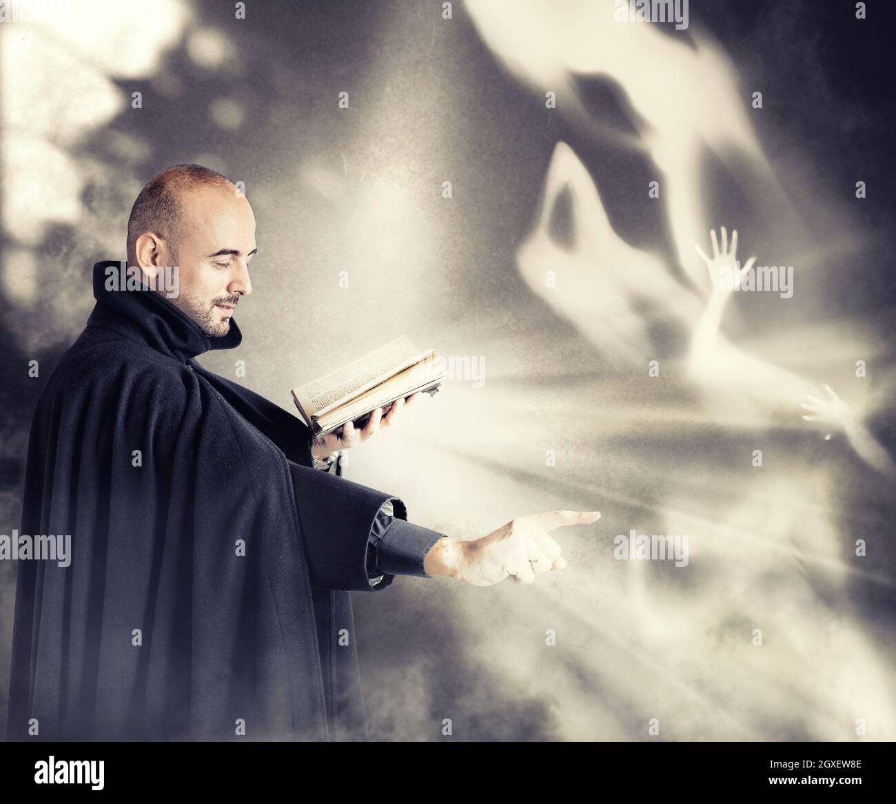 Exorcist priest fights a demon in a dark room Stock Photo - Alamy