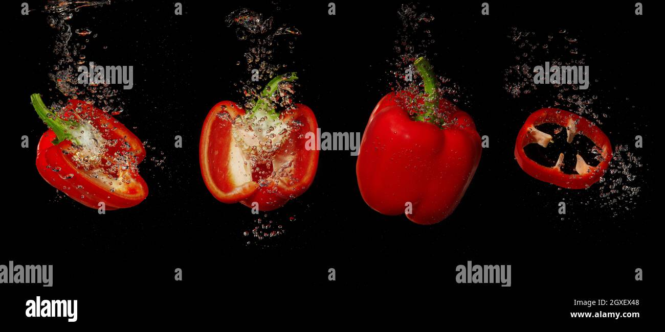 Red pepper splashing in water on a black background Stock Photo - Alamy