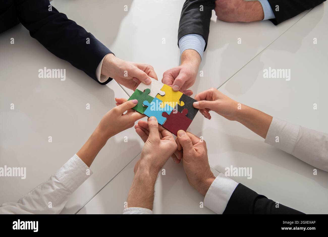 Businessmen working together to build a colored puzzle. Concept of ...