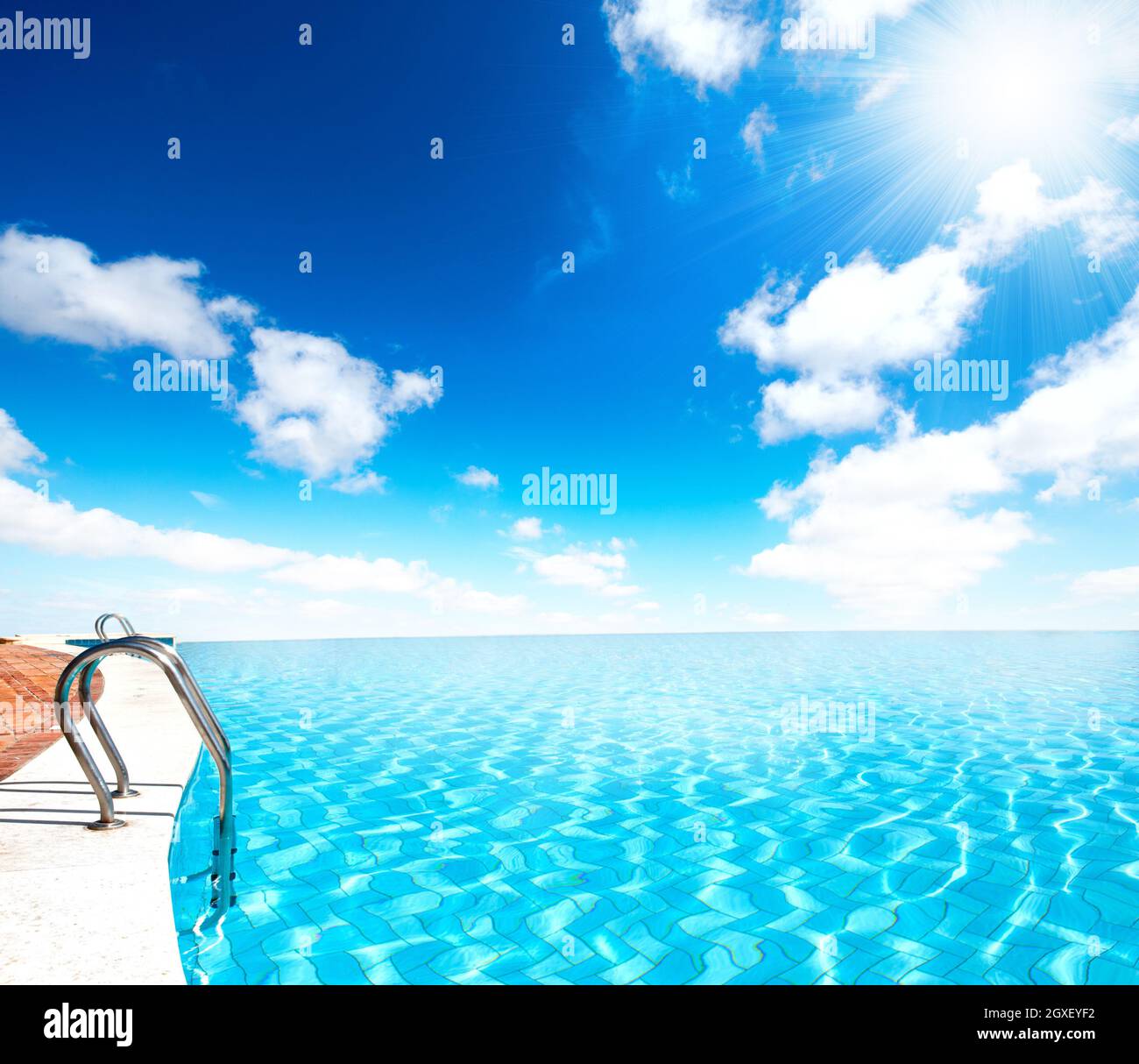 Infinite swimming pool with sun ray Stock Photo - Alamy