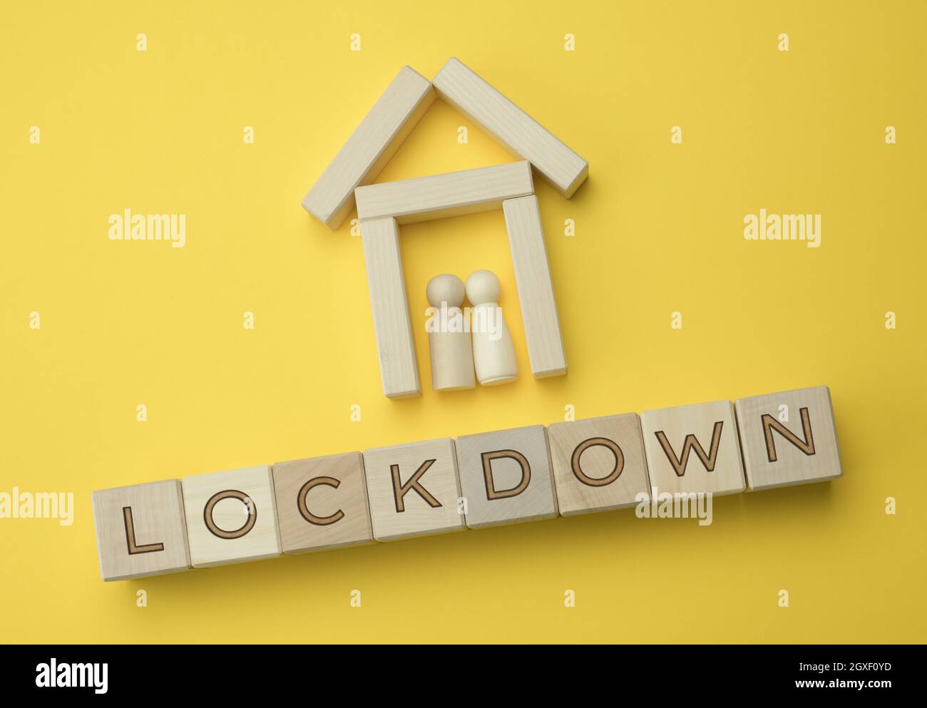 two wooden figures of a family inside a decorative house and an ...