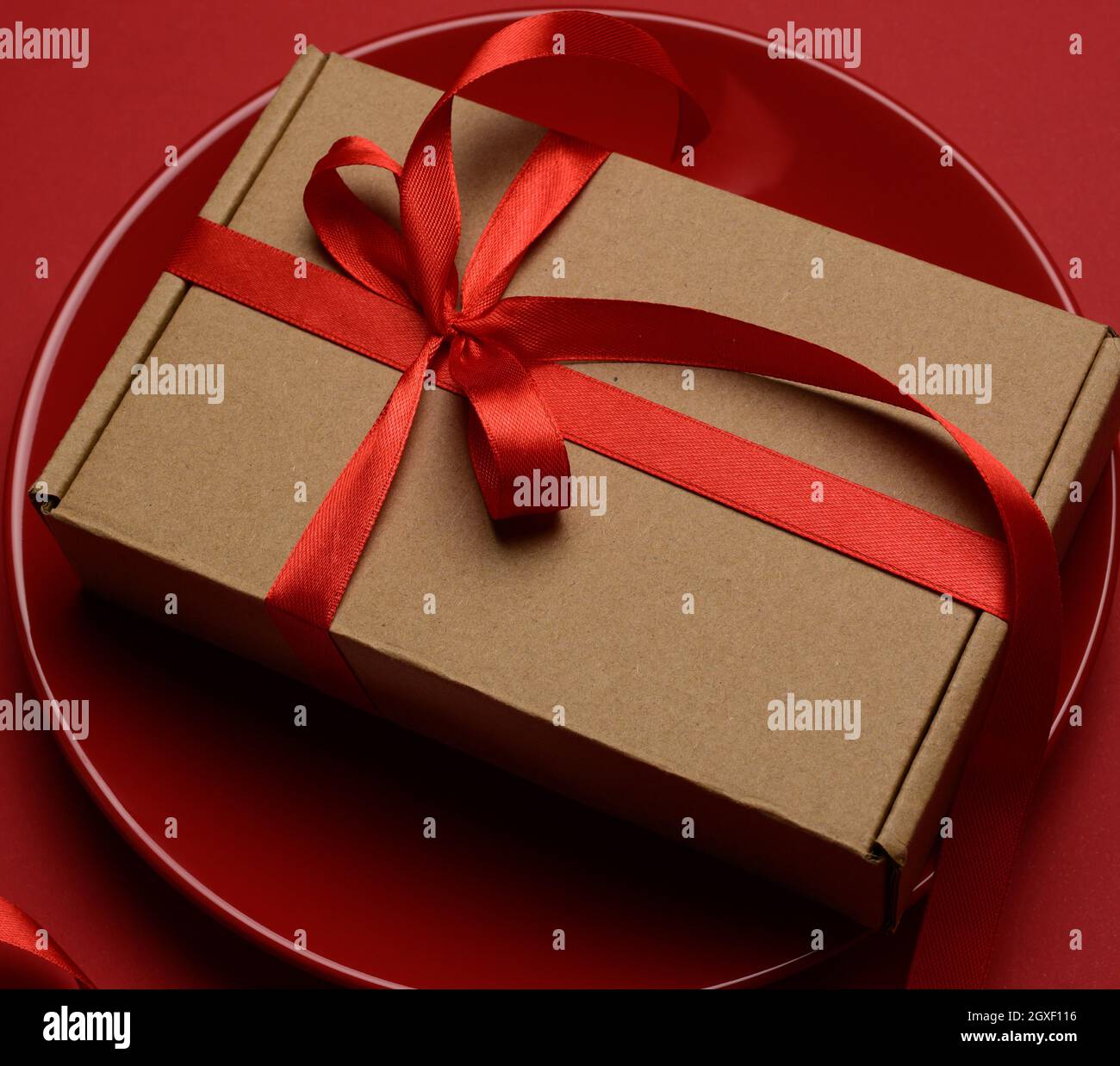 rectangular brown cardboard box tied with a silk red ribbon lies in a ...