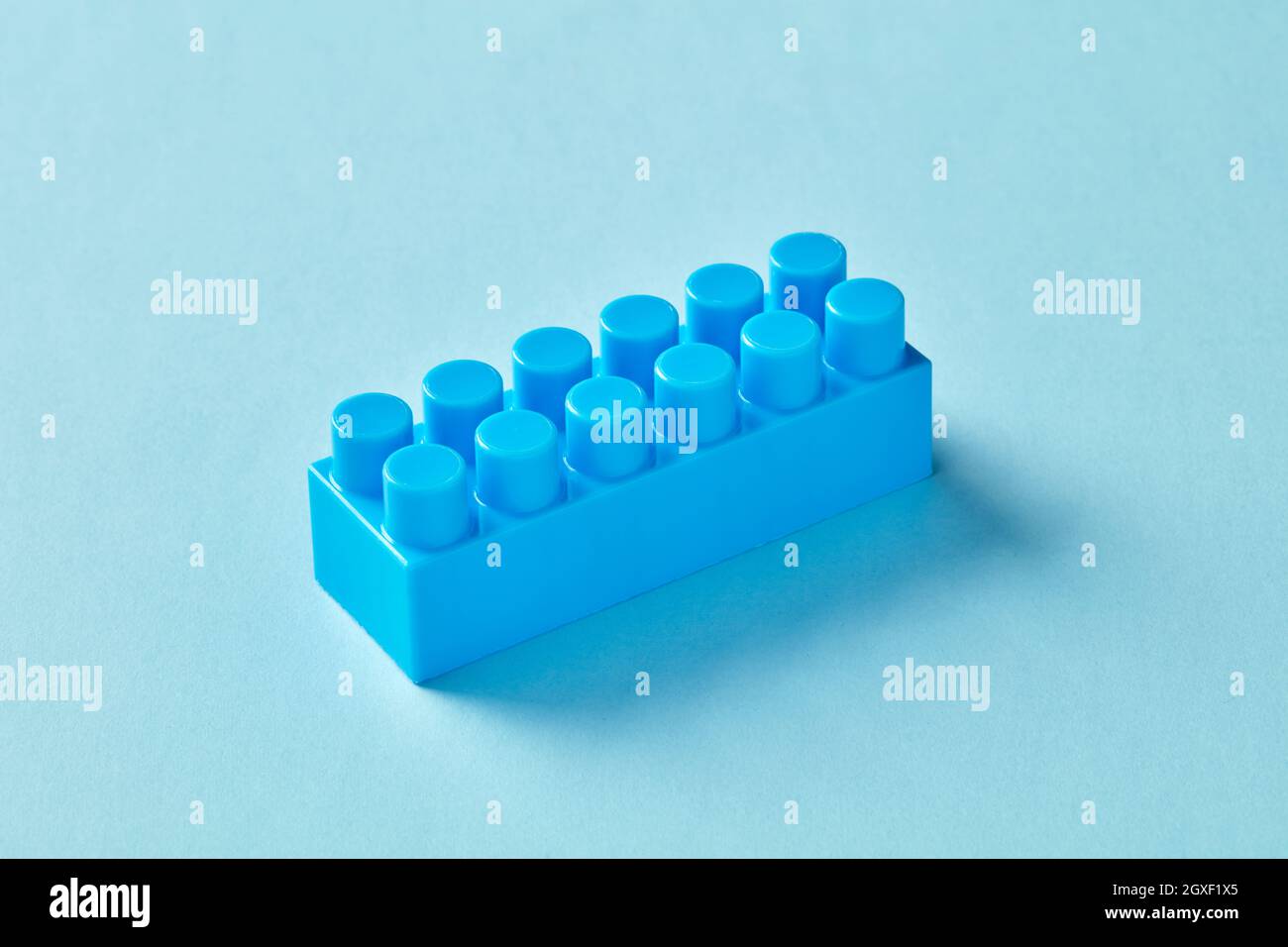 Blue toy brick on blue background Stock Photo - Alamy