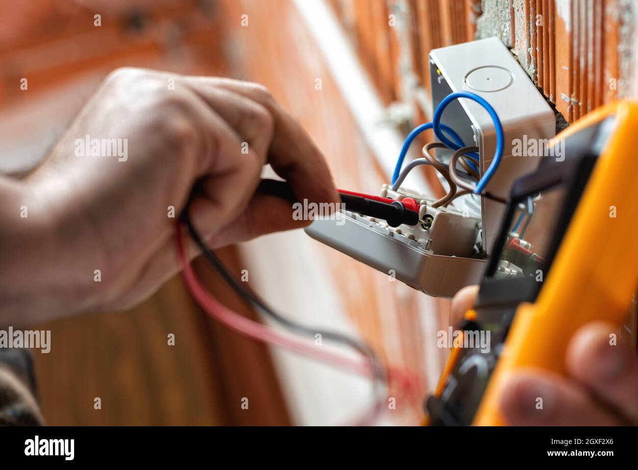 Bottom view. Electrician worker at work with the tester measures the ...