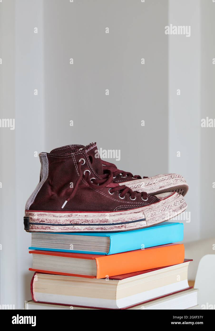 Old canvas shoes on books stack Stock Photo - Alamy