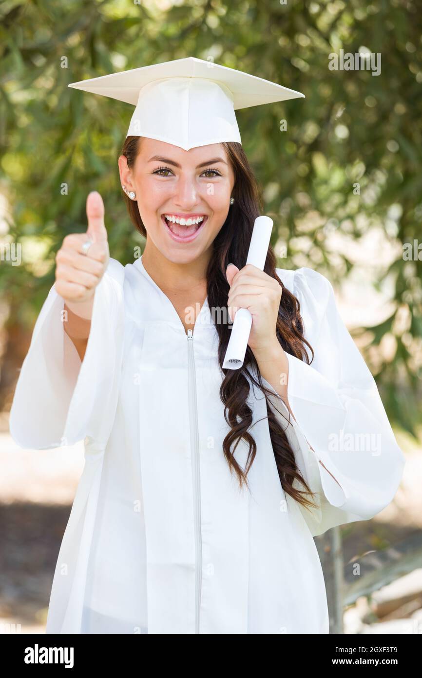 Mixed Race Thumbs Up Girl Celebrating Graduation Outside In Cap and ...