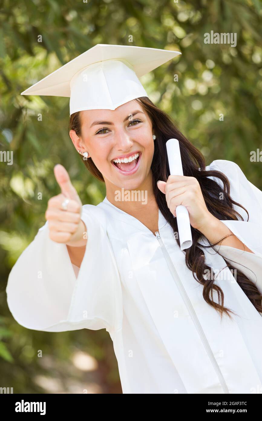 Mixed Race Thumbs Up Girl Celebrating Graduation Outside In Cap and ...