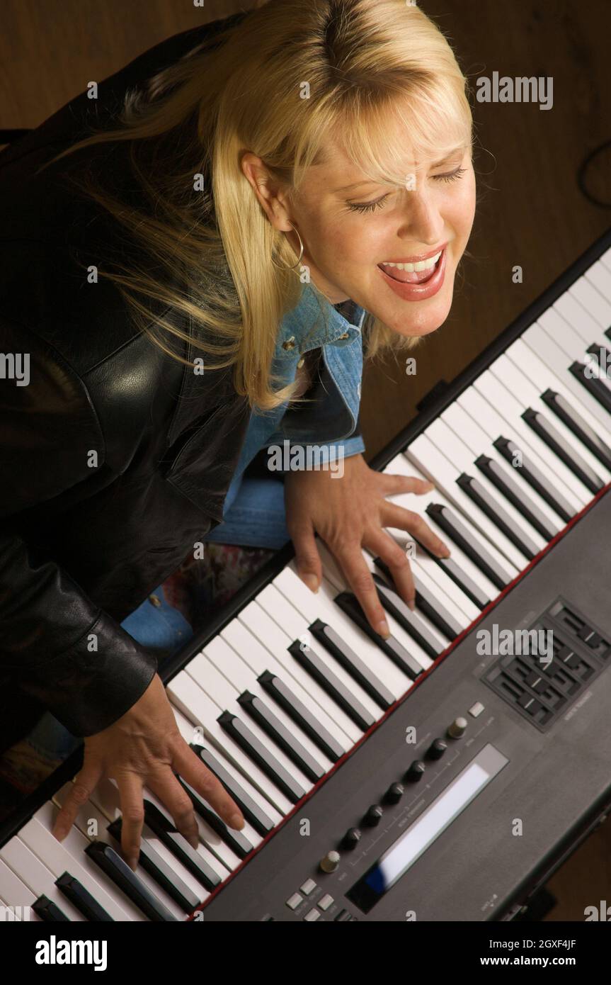 Female Musician Sings While Playing Digital Piano Stock Photo - Alamy