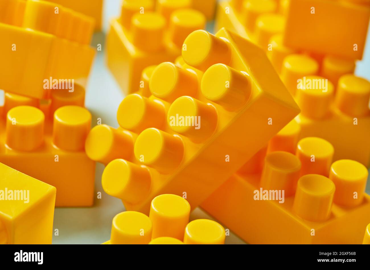Plastic yellow toy blocks on blue background Stock Photo - Alamy