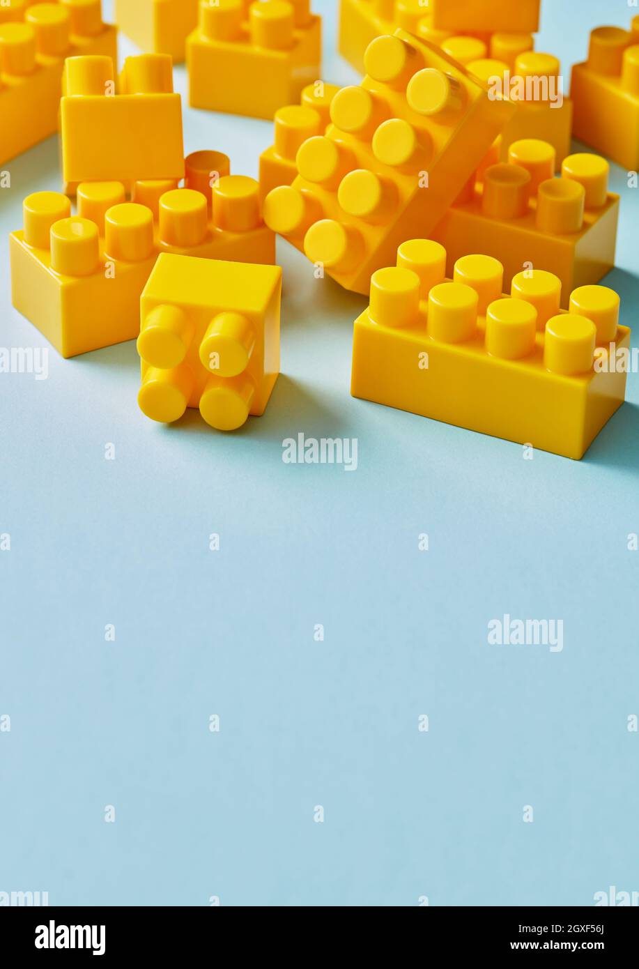Plastic yellow toy blocks on blue background Stock Photo - Alamy
