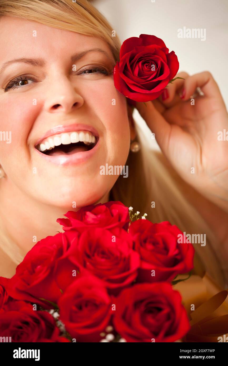 Beautiful Woman with a Bunch of Red Roses and Places One Above Her Ear ...