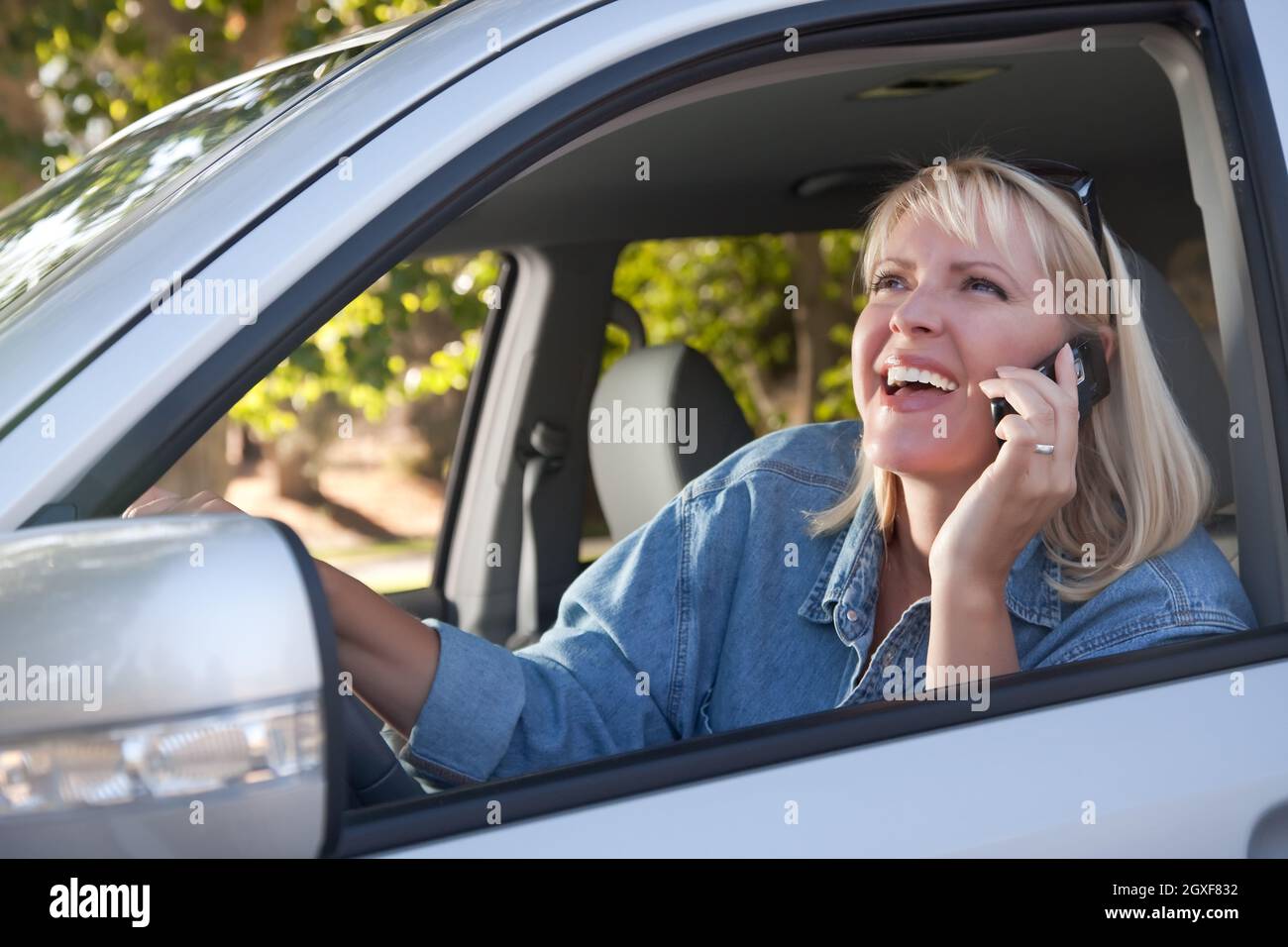Attractive Blonde Woman Using Cell Phone While Driving Stock Photo - Alamy