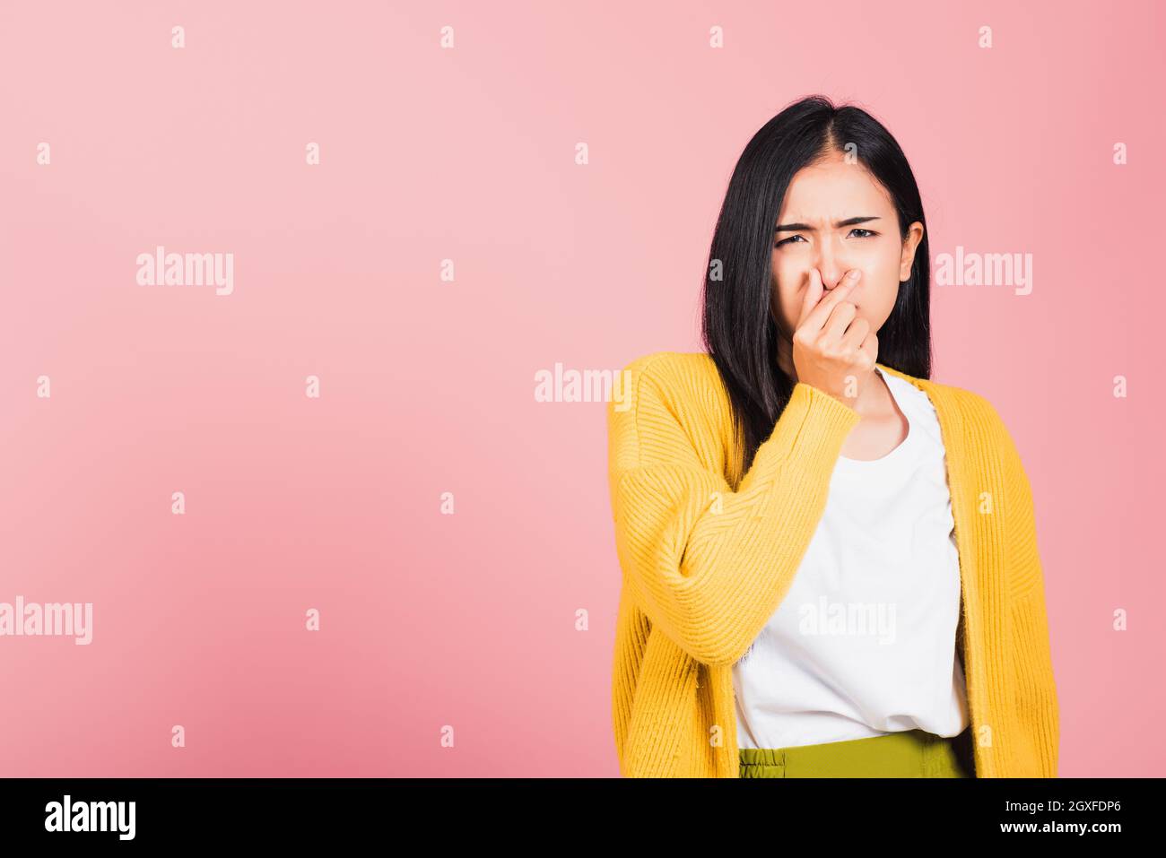 Asian beautiful young woman unhappy what a smell disgust expression ...