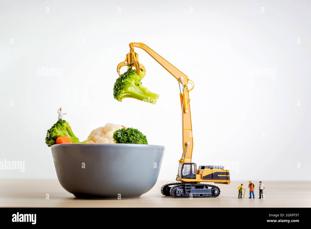 Miniature people making salad. Cooking concept Stock Photo - Alamy