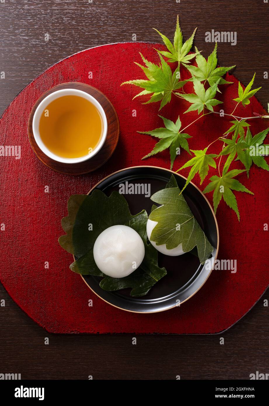 Kashiwa Mochi on a red tray. Kashiwa Mochi is a Japanese confectionery ...