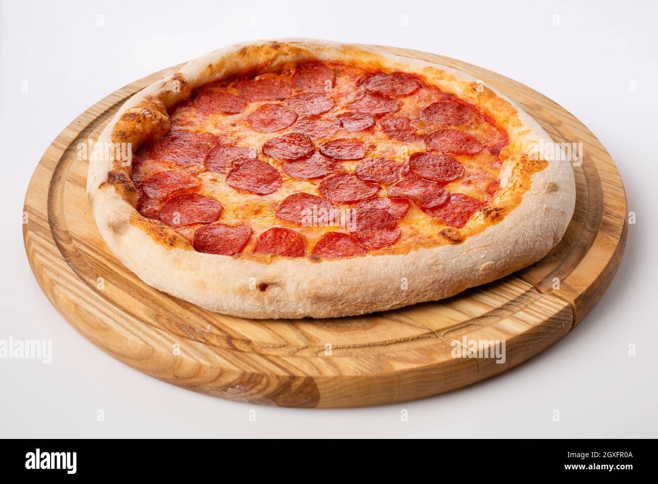 Top view of hot pizza on a wooden stand. Pepperoni pizza. Tomato base ...