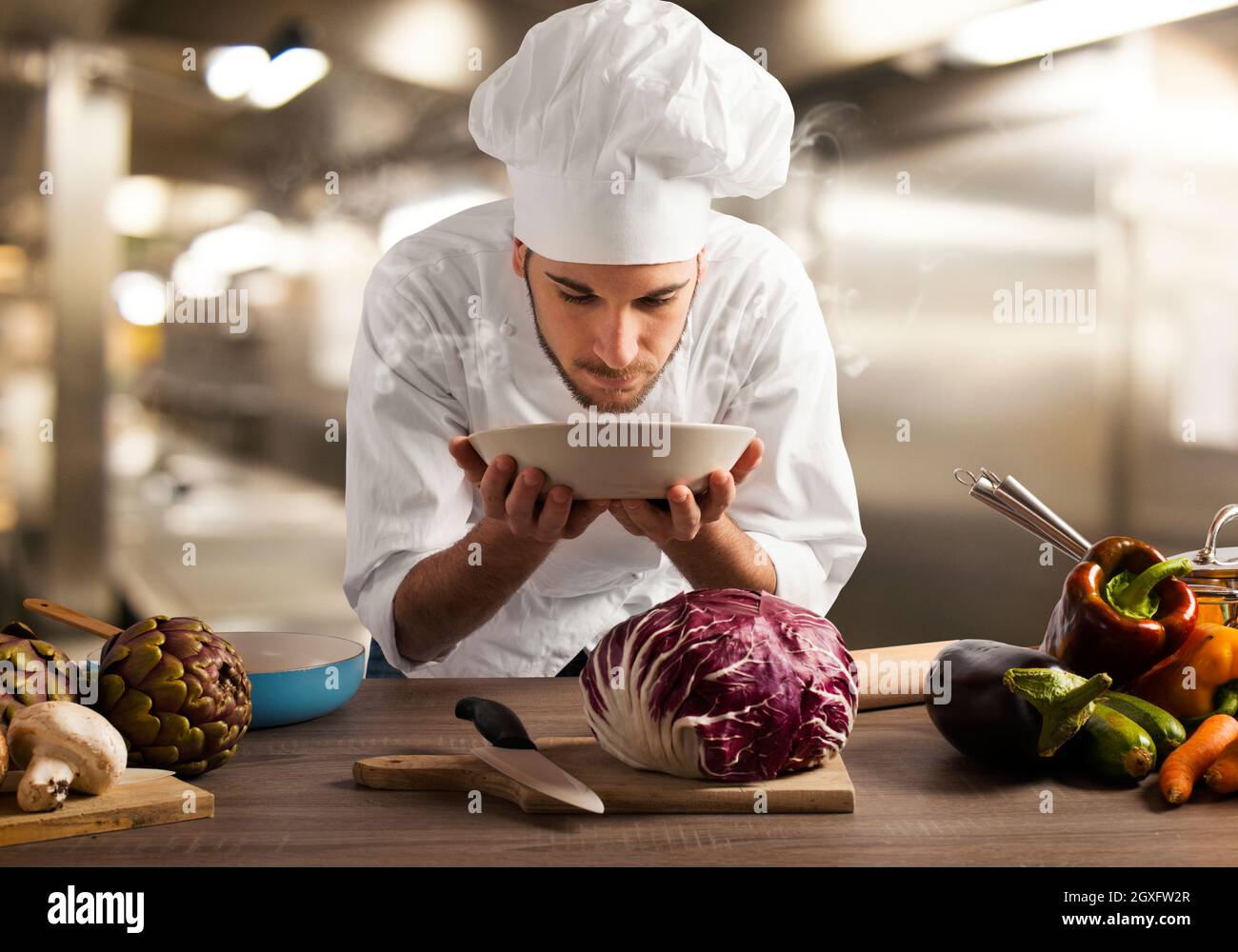 Chef smelling the aroma of a dish at the restaurant kitchen Stock Photo ...