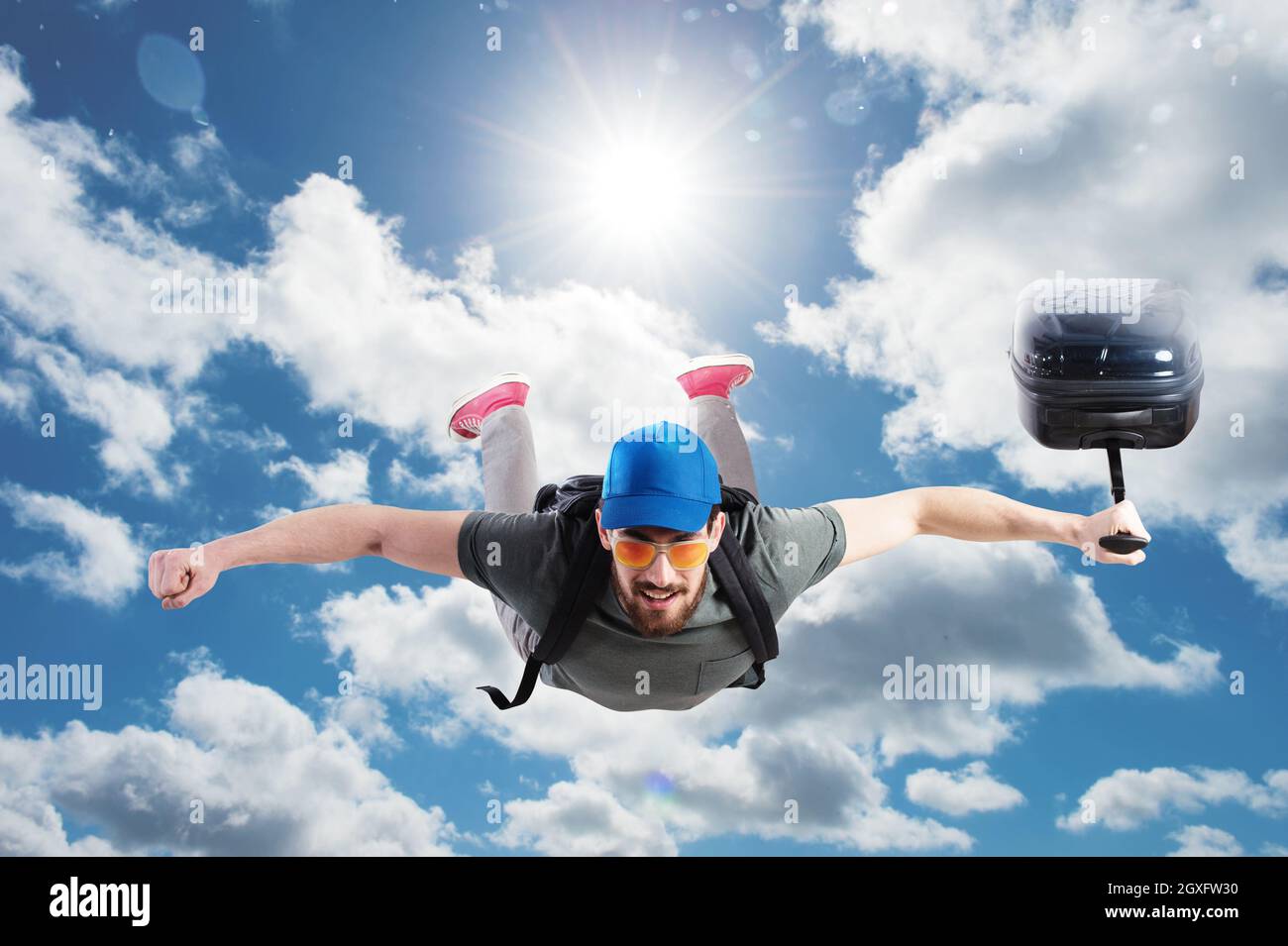 Man flies in the sky with baggage ready to vacation Stock Photo - Alamy