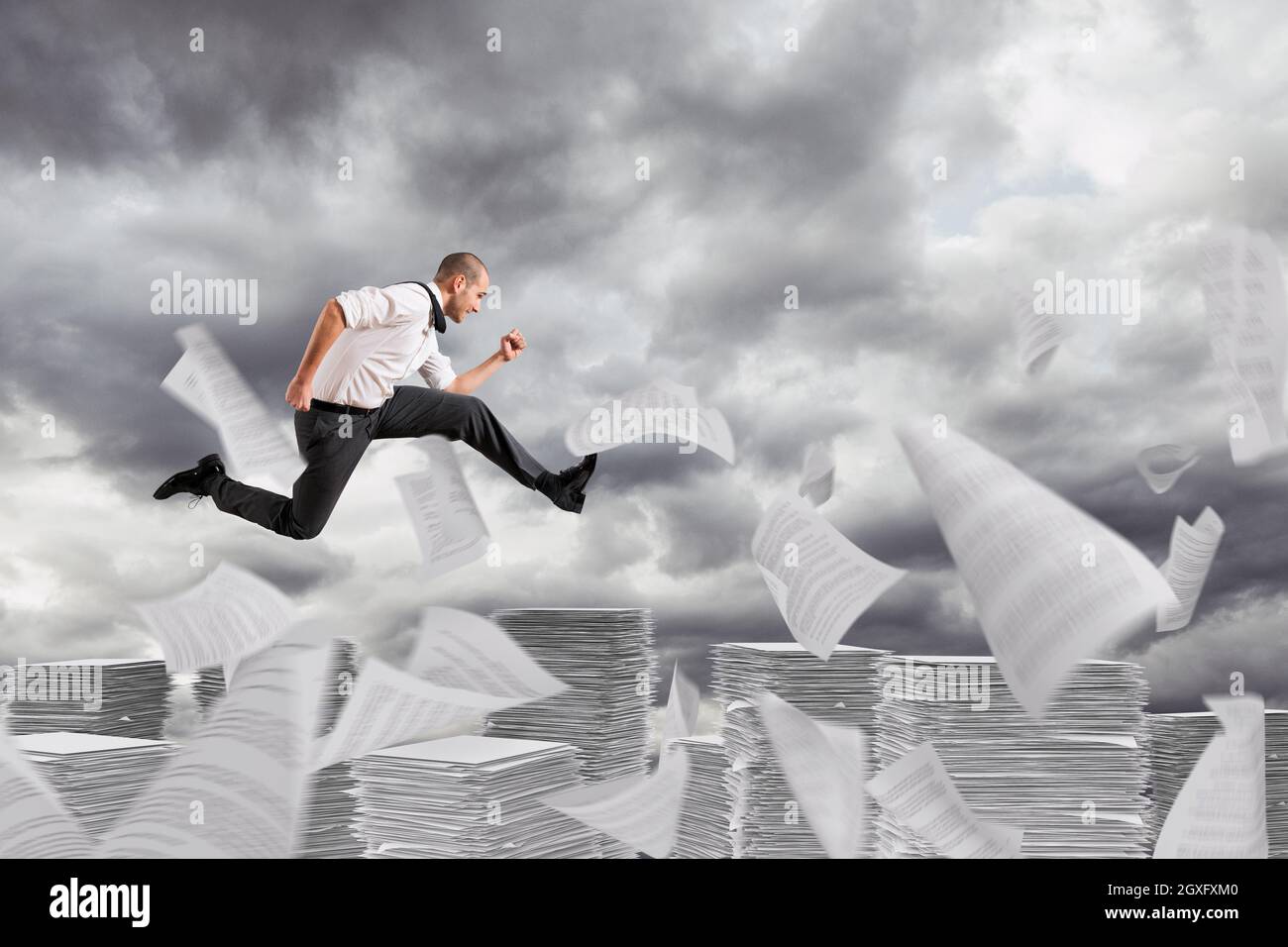 Businessman jumps over columns of paper sheets Stock Photo - Alamy
