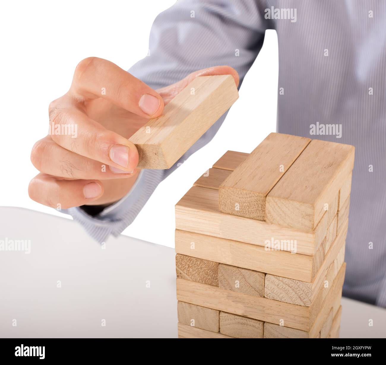 Man puts the last wood block of puzzle Stock Photo - Alamy