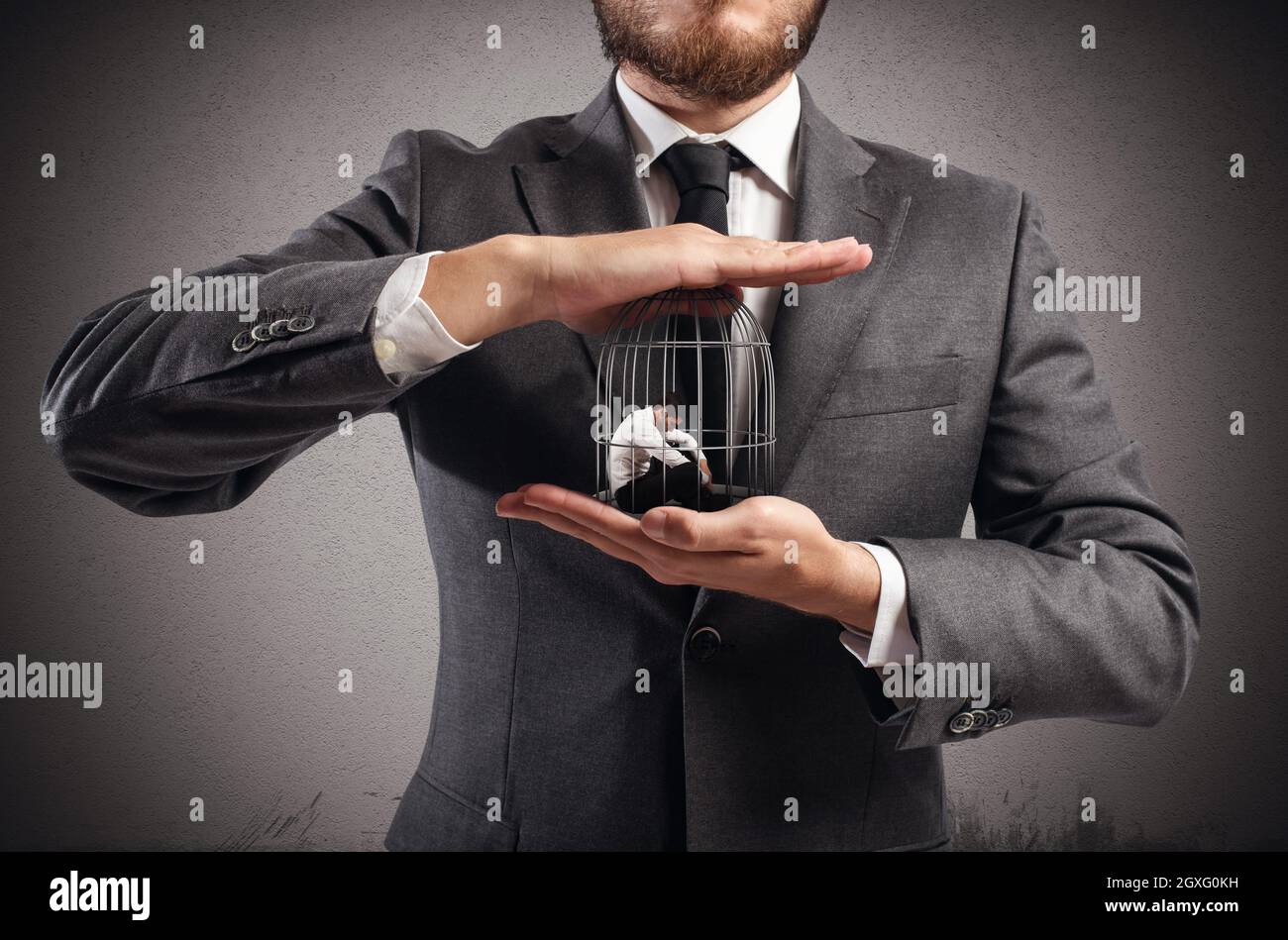 Boss holds in hands a caged man Stock Photo - Alamy