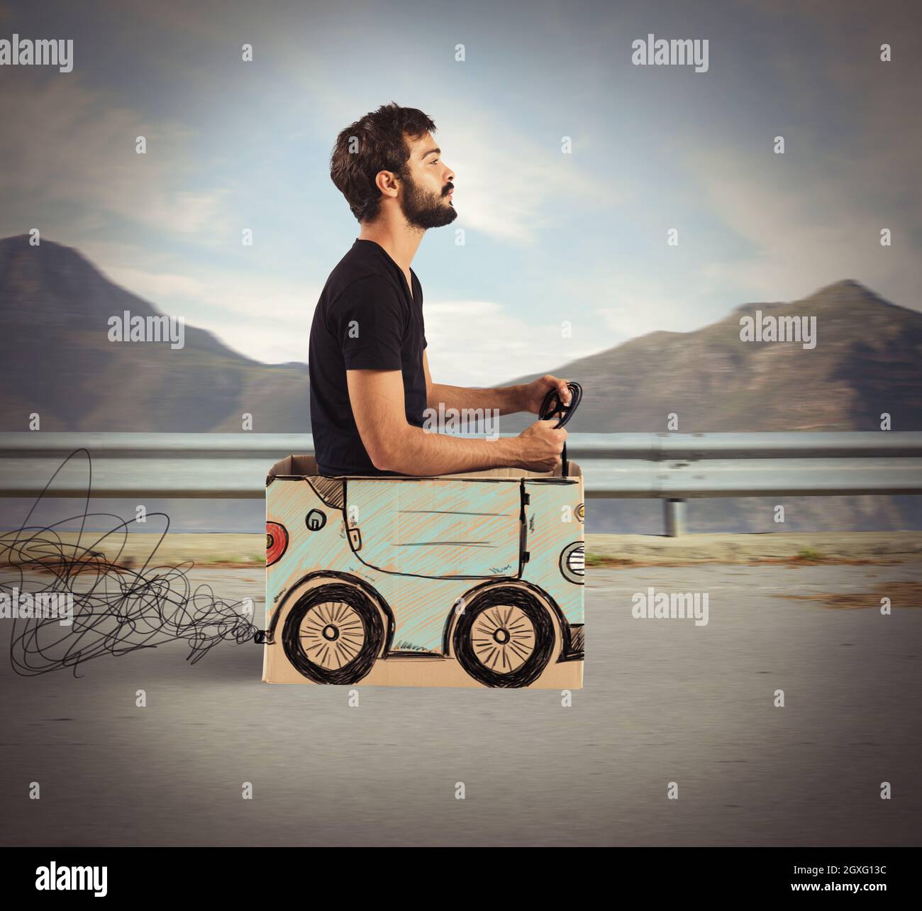 Boy driving cardboard car in mountain road Stock Photo - Alamy