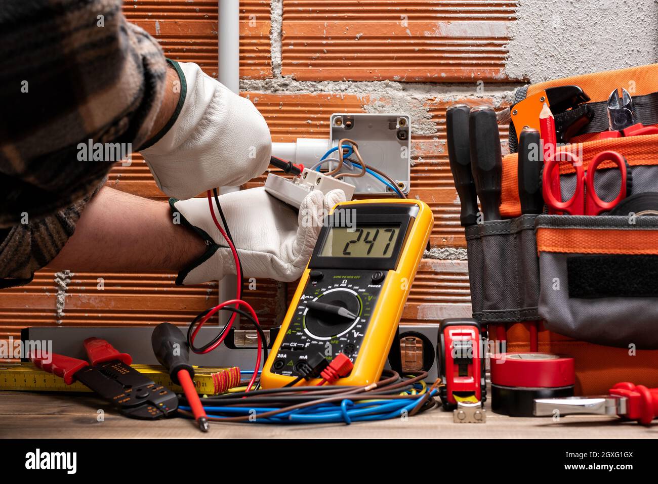 Electrician worker at work with the tester measures the voltage in an ...