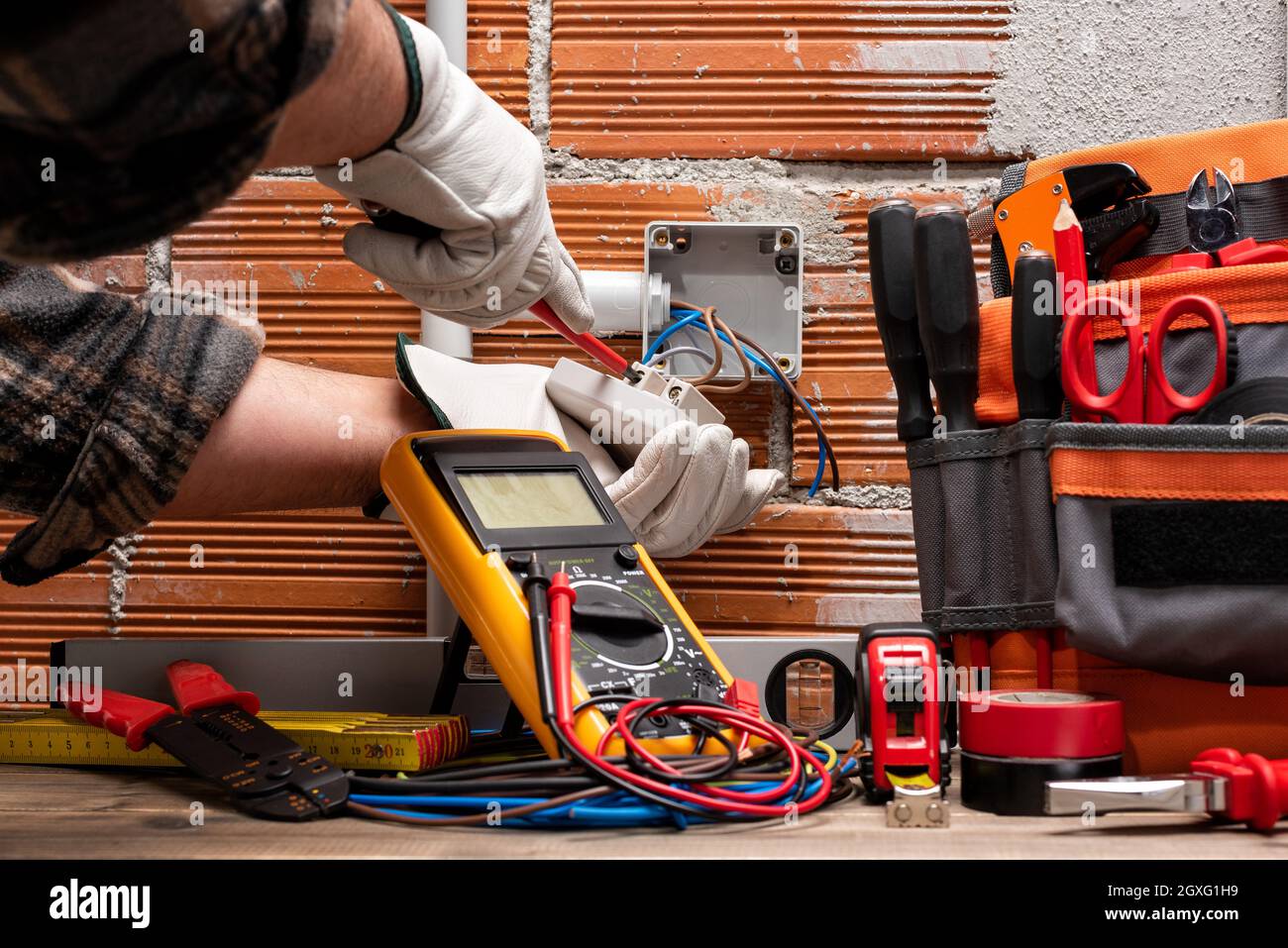 Electrician worker with a screwdriver fixes the cable in the terminal ...