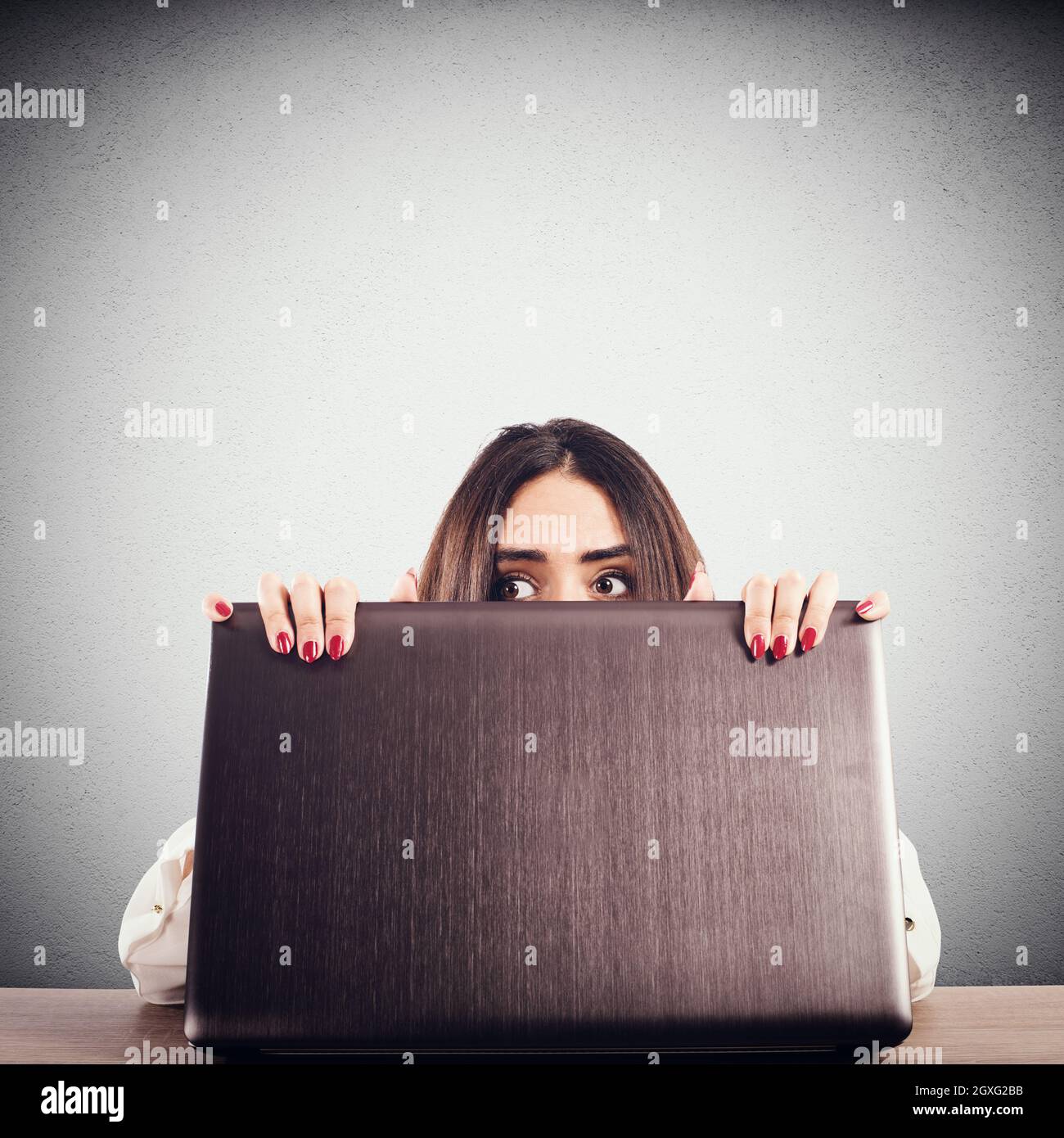 Woman hidden behind the computer screen peeks secretly Stock Photo - Alamy