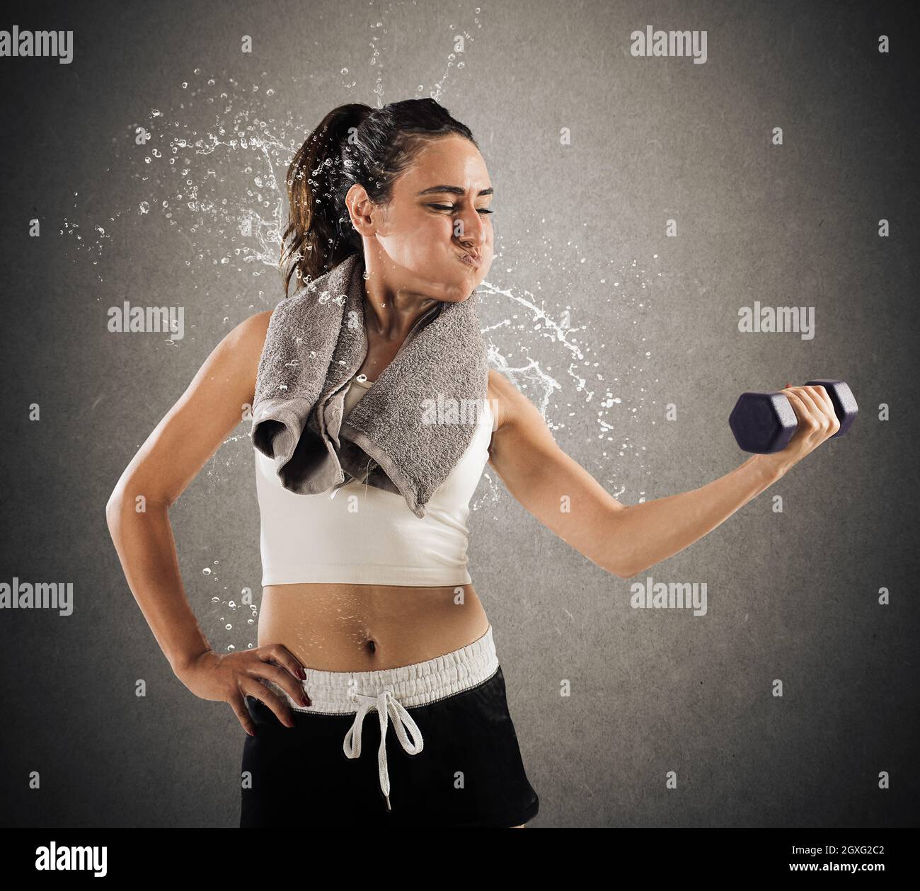 Woman raises a dumbbell weight sweating so much Stock Photo - Alamy