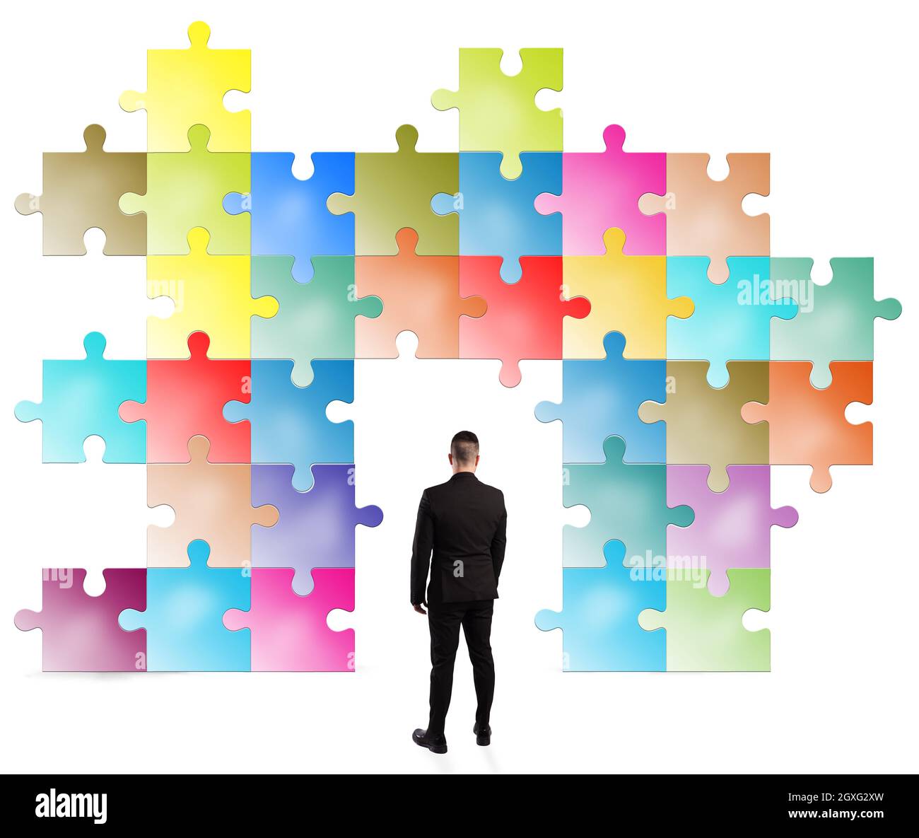 Man looks a puzzle built with colored pieces Stock Photo - Alamy