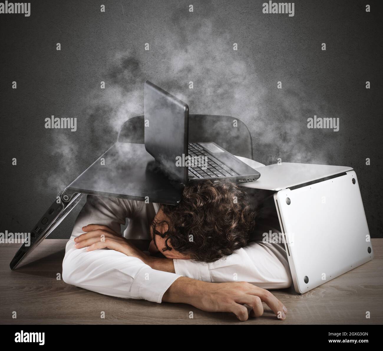 Tired businessman sleeping under a pile of computers Stock Photo - Alamy