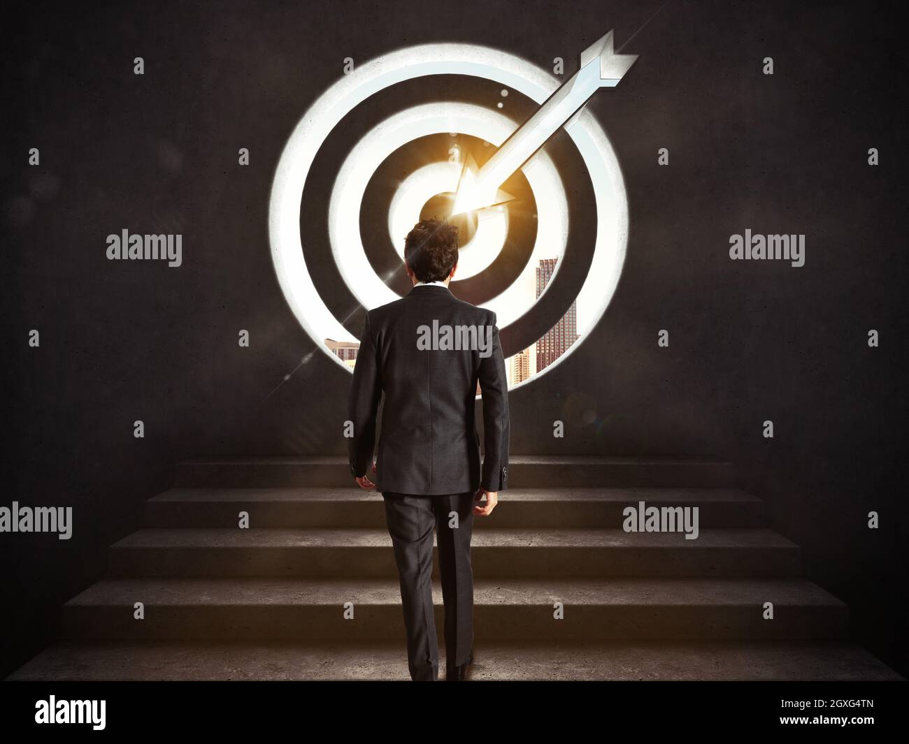 Businessman climbing the stairs up to a target with the arrow etched in ...