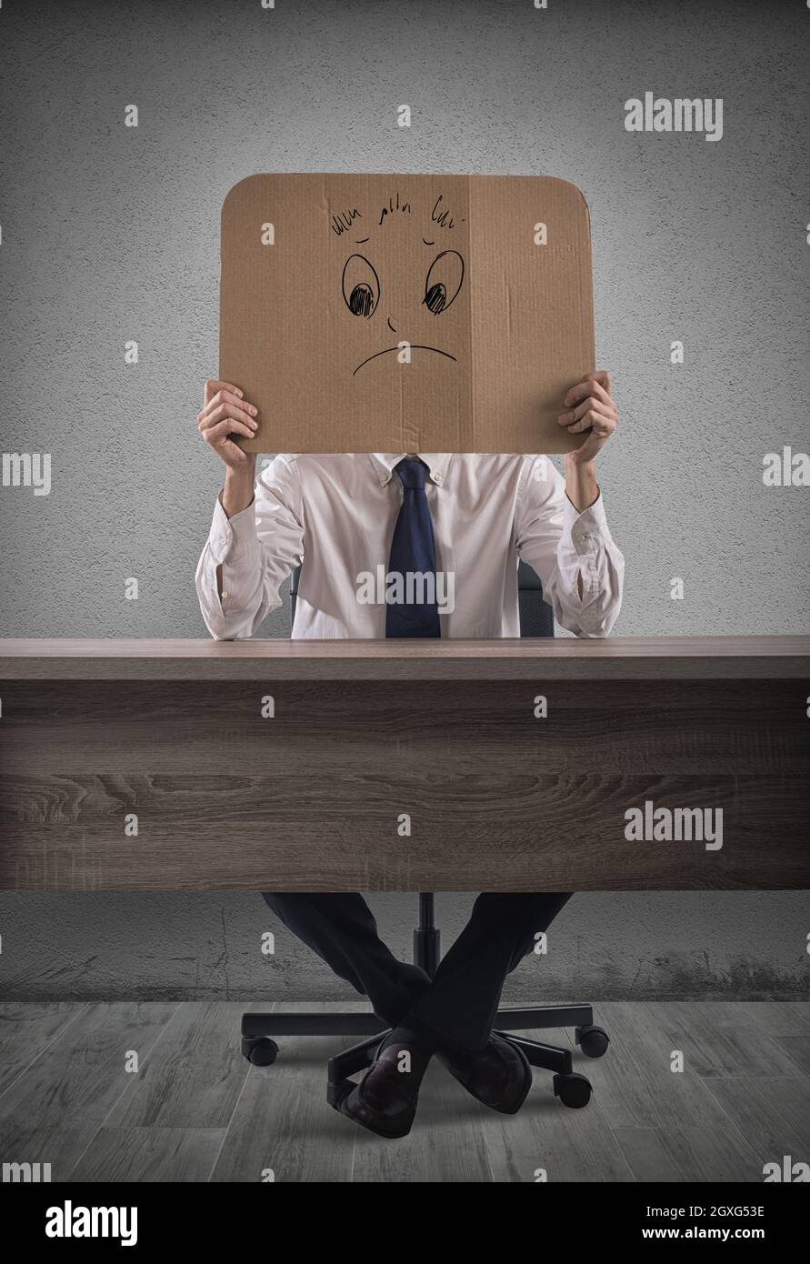 Businessman in the office holds a cardboard with a sad face Stock Photo ...