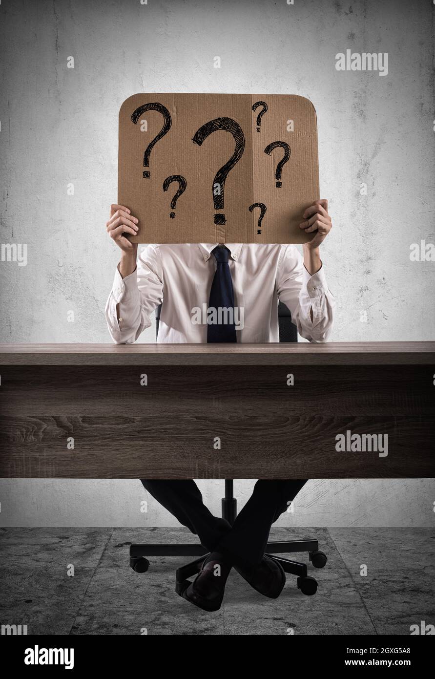 Businessman in the office holds a cardboard with question marks Stock ...