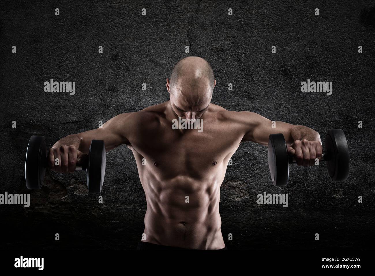 Athletic muscular man training biceps with dumbbells Stock Photo - Alamy