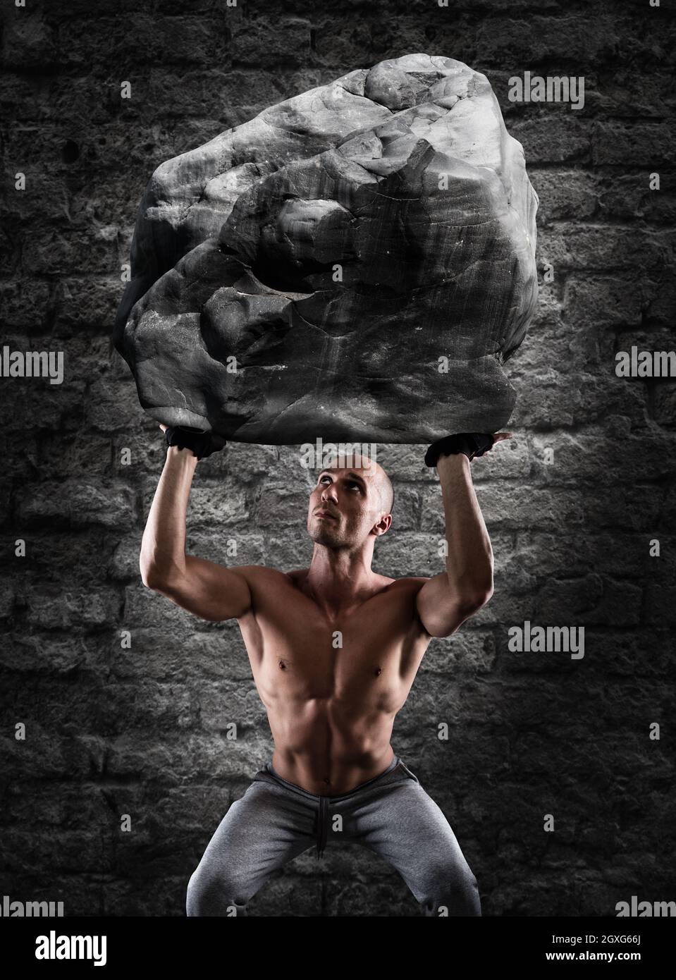 Muscular man with determination lifts a big boulder Stock Photo - Alamy