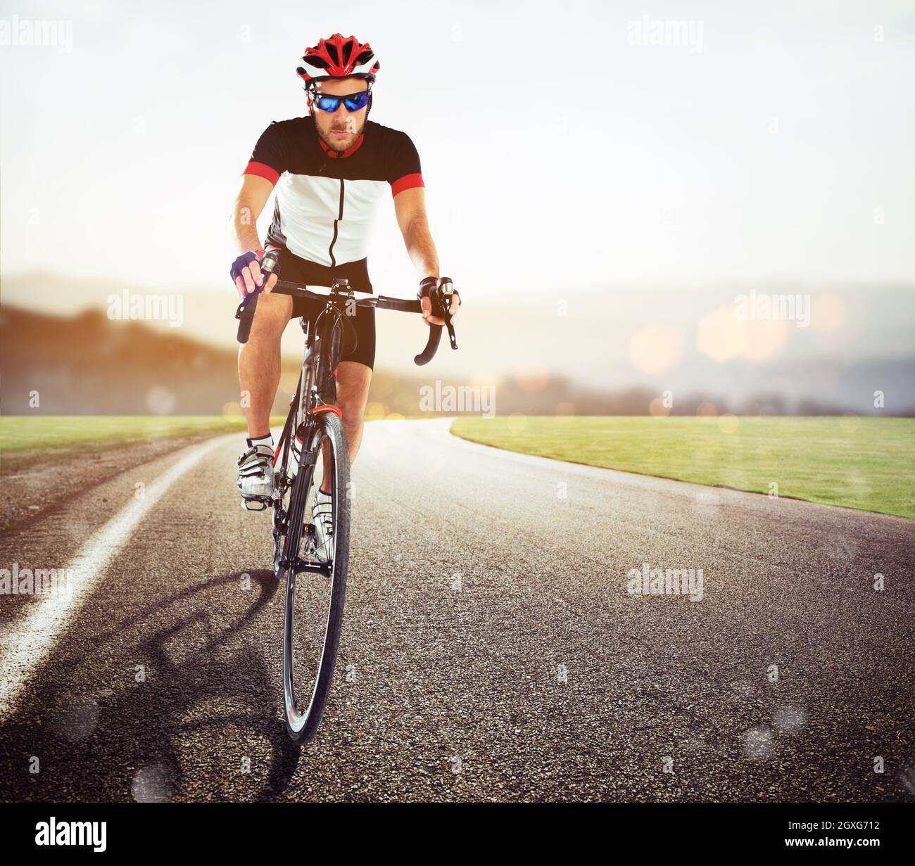 Front view of a road cyclist in uniform during a race at sunset Stock ...